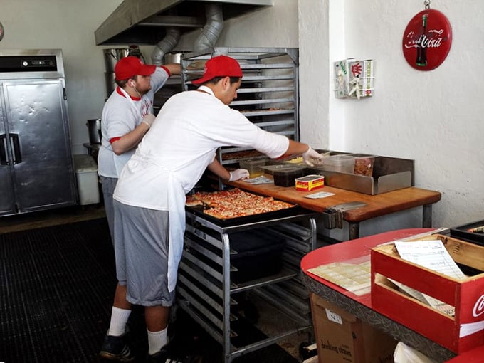 Behind-the-scenes pizza magic happening in real time, where decades of expertise meet fresh dough every single day.