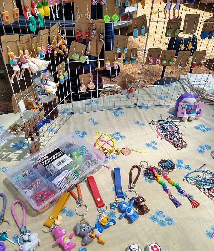 Keychains and trinkets displayed on flowered tablecloths, because even your car keys deserve a personality upgrade for cheap.