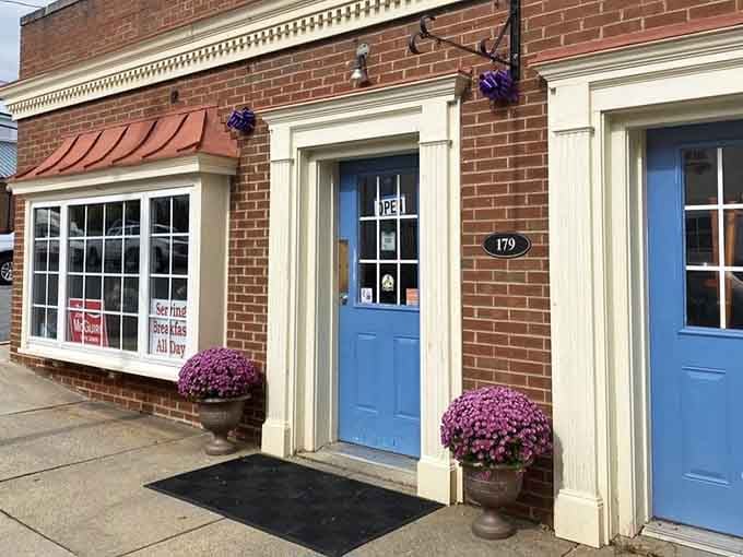 Purple mums frame the blue door entrance, adding cheerful color to your seafood pilgrimage today.