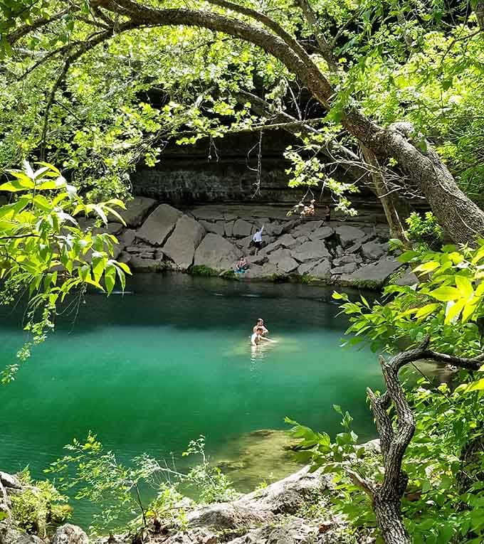 Emerald waters beckon swimmers into a natural pool where limestone walls provide shade better than any beach umbrella.