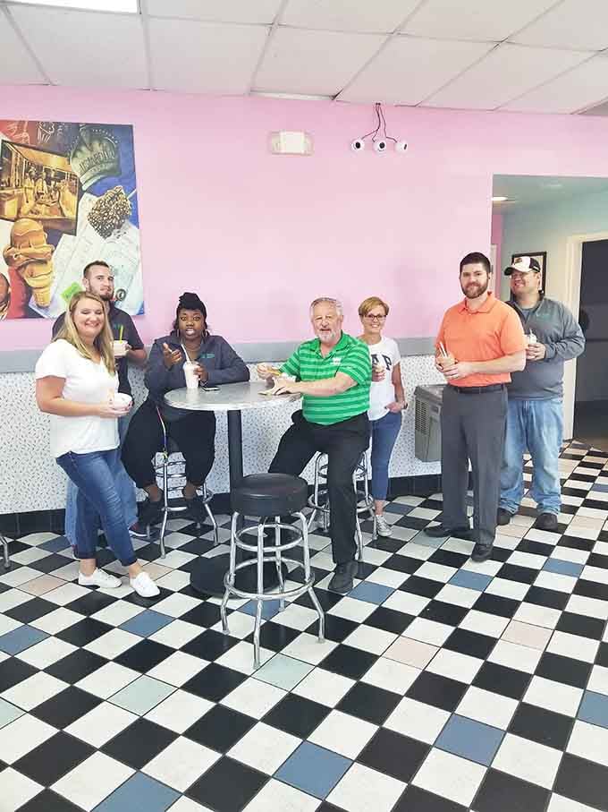 Multiple generations gathered around custard proves some traditions transcend age, creating perfect moments together.