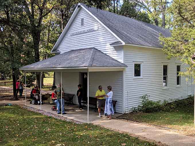 Costumed interpreters bring history alive under the schoolhouse porch, proving learning beats scrolling any day of the week.