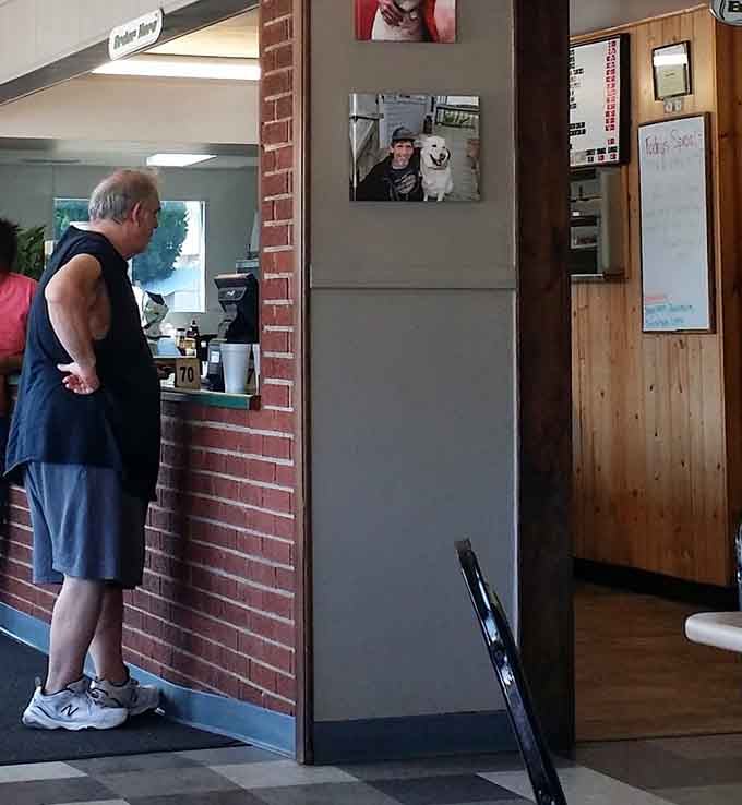The order window frames the kitchen action while locals chat at the counter like they're catching up with family.