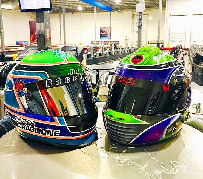 Custom racing helmets proving that safety gear can actually look cooler than your regular Tuesday afternoon outfit.