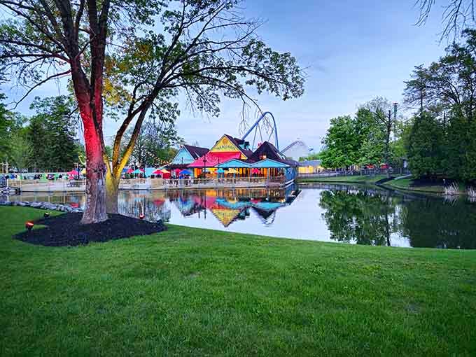 Evening reflections turn the park into a watercolor painting, where coasters dance across the glassy surface like dreams.