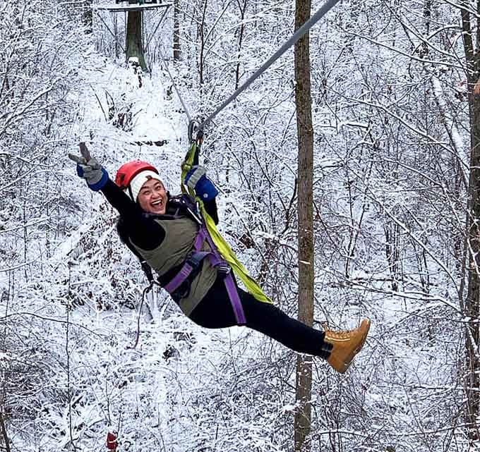 Pure joy captured mid-flight through a winter wonderland, arms raised in triumphant celebration of courage.
