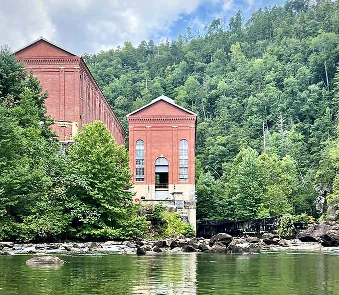 The stately powerhouse reflected in calm waters proves that industrial heritage and natural beauty can actually coexist quite harmoniously together.
