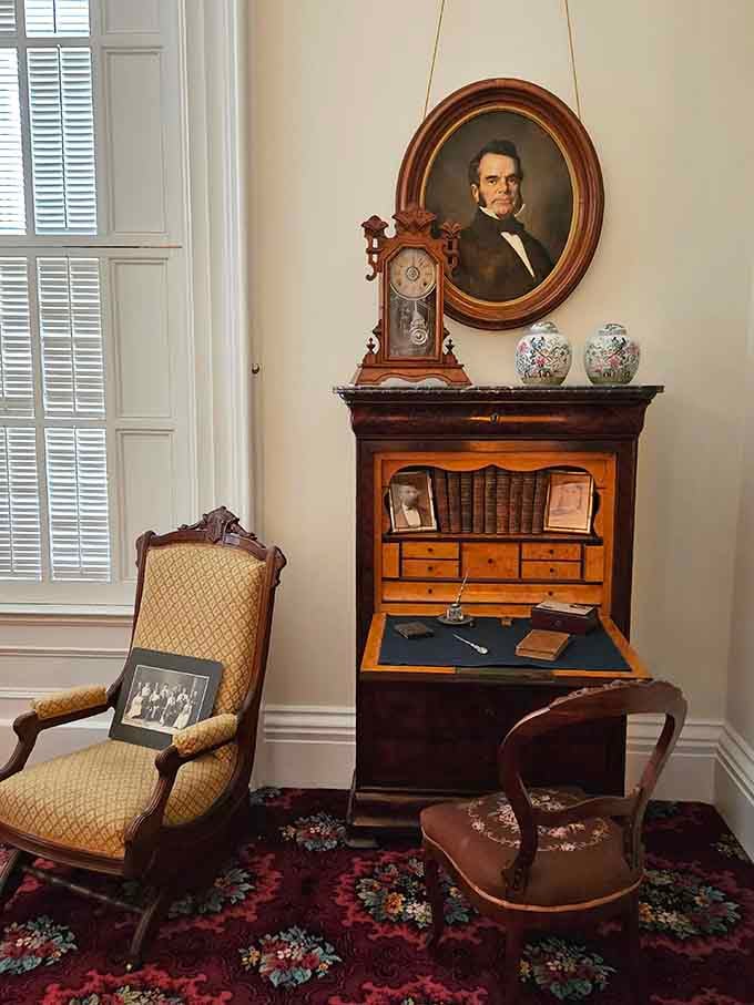 That portrait watches over a secretary desk filled with vintage writing implements, back when correspondence required actual penmanship and patience.