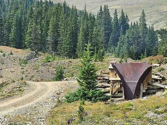 An ore bin sits abandoned on the hillside, once crucial infrastructure now slowly becoming part of the landscape.