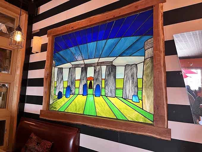 Colorful stained glass artwork adds unexpected whimsy to the dining room's contemporary industrial design aesthetic.