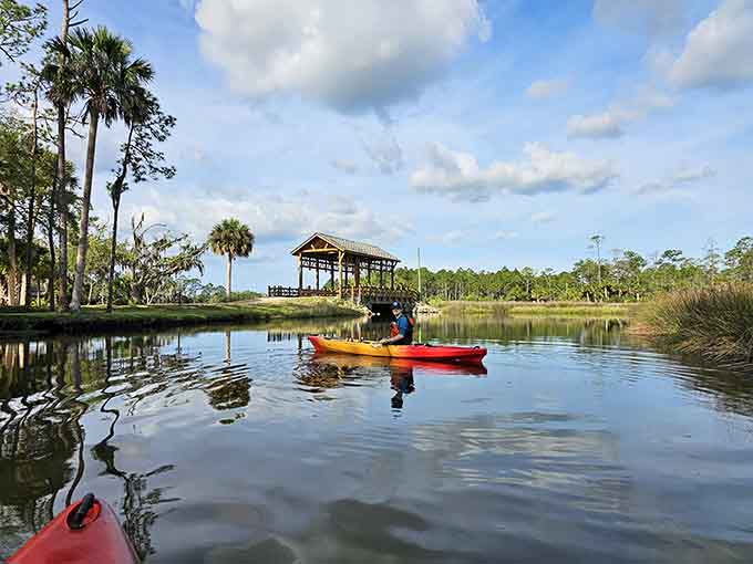 Kayakers glide past covered pavilions, living their best life while the rest of us are stuck in traffic somewhere.