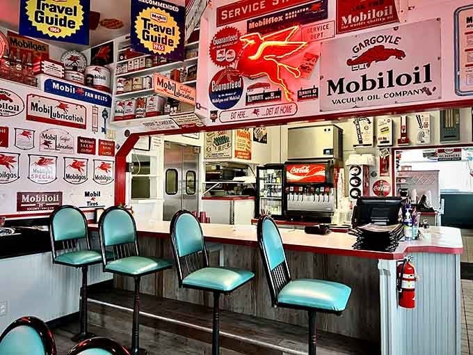 Counter seating surrounded by vintage Mobiloil signs creates an immersive experience that transports you back in time.