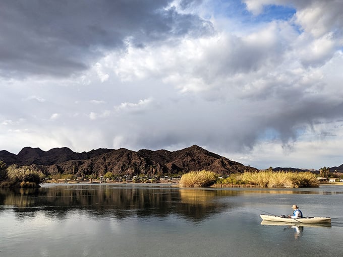 Kayaking under dramatic clouds that can't decide between sunshine and rain, keeping things interesting for paddlers.