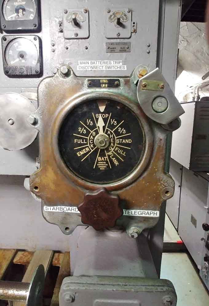 The starboard engine order telegraph still shows its original markings, a direct connection to wartime command decisions.