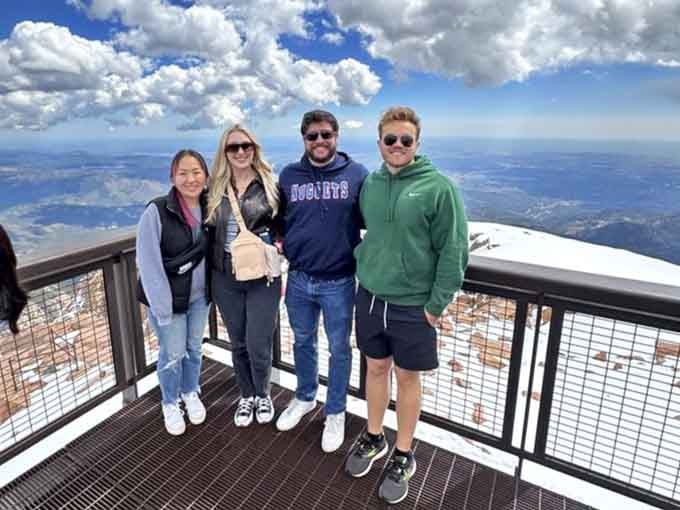 Happy visitors at the summit prove that reaching the top without gasping for air is absolutely worth celebrating together.