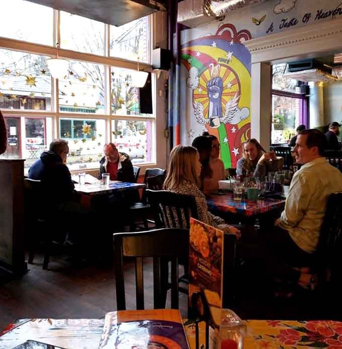 Natural light streams through tall windows as happy diners enjoy conversations over steaming plates of breakfast bliss together.