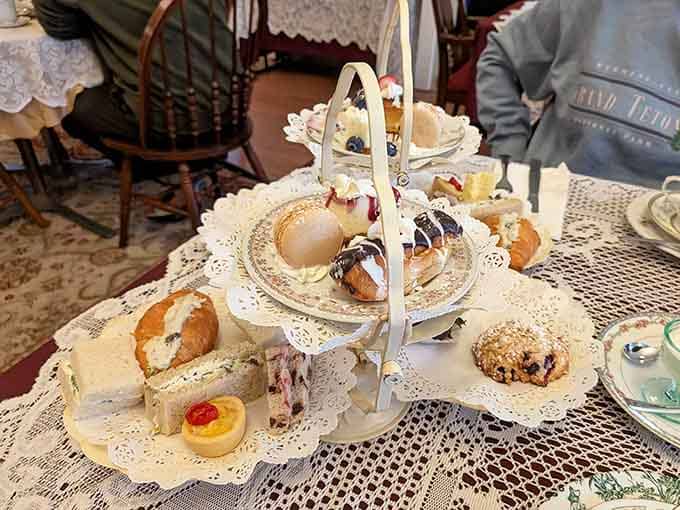 That three-tiered stand arrives like a tower of edible happiness at your linen-draped table.