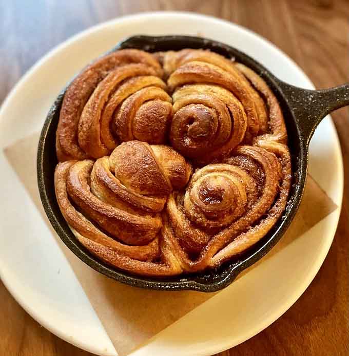A skillet of cinnamon-sugar swirled dough that arrives looking like edible art and disappears like it's going out of style.