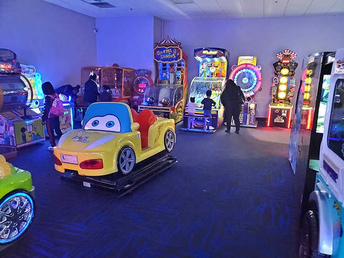 The arcade area glows with possibilities, offering entertainment variety beyond the main attraction's educational driving focus.