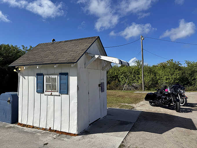 Blue shutters and white siding give this former shed more charm than most modern postal facilities combined.