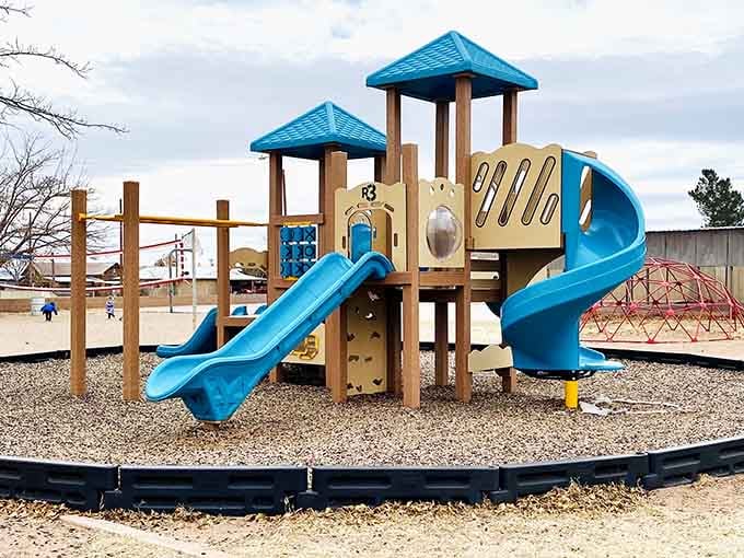 The playground's bright blue slides stand out against the desert landscape like an oasis for traveling families.