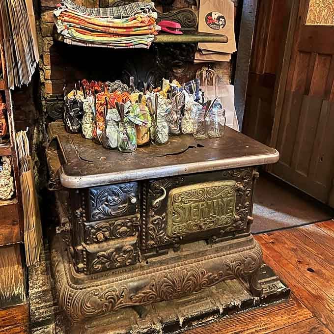 An antique cast-iron stove displaying colorful bottles like museum pieces, blending function with folk art in unexpected harmony.