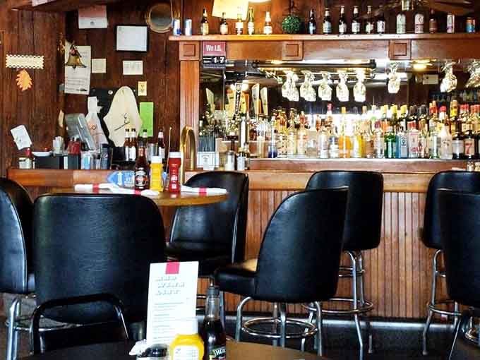 Wood paneling and bar stools create that classic tavern vibe where everybody feels like a regular immediately.