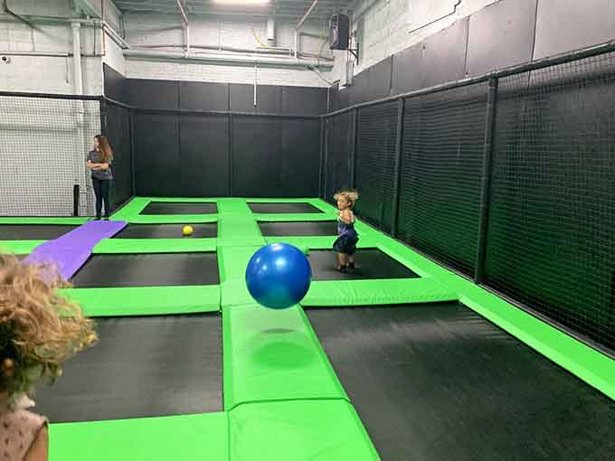 Trampolines stretch across the floor in electric green, practically begging visitors to test their vertical leap and inner astronaut.