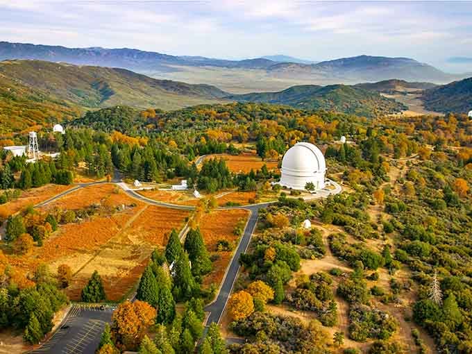 That white observatory dome rises like a pearl among autumn colors, where science meets nature's spectacular show.