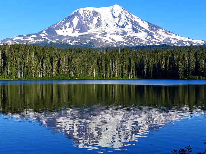 Mount Adams reflects perfectly in glassy waters, creating a mirror image that even the best photographers can't improve.