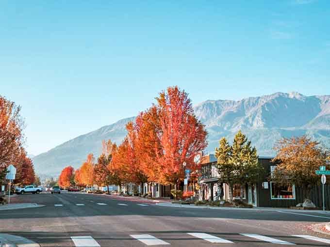 Fall colors explode along the avenue, turning ordinary trees into flames of orange and red against mountain backdrops.