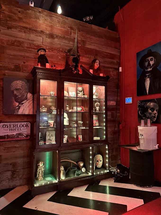 A glass cabinet full of horror collectibles, including a Jason Voorhees mask, watching over the room with quiet menace.