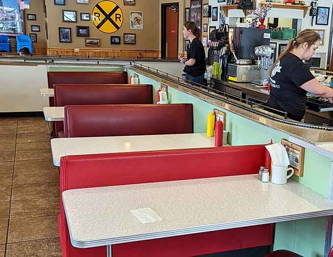 Classic red vinyl booths and overhead tracks create the perfect marriage of retro diner charm and railway magic.