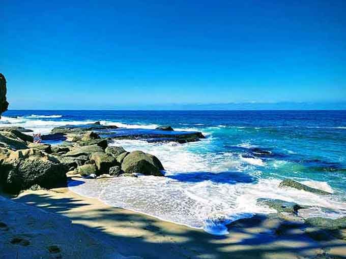 Rocky coastline meets sandy beach in the kind of natural collaboration that actually works perfectly.