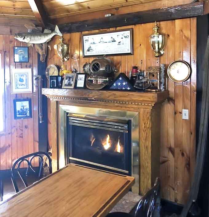 A cozy fireplace surrounded by fishing trophies and memories, perfect for warming up after Lake Erie's chilly embrace.