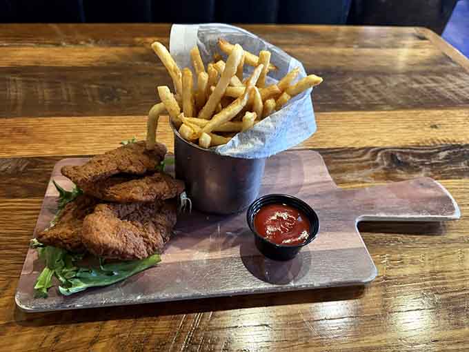 Chicken tenders and fries served on a wooden paddle, because regular plates simply couldn't contain this level of fried excellence.