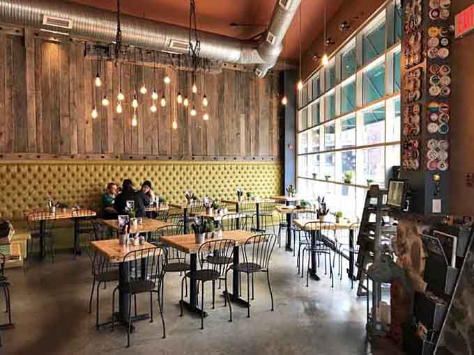 Tufted yellow banquette seating adds a pop of sunshine to the industrial space, making every meal feel slightly fancy.