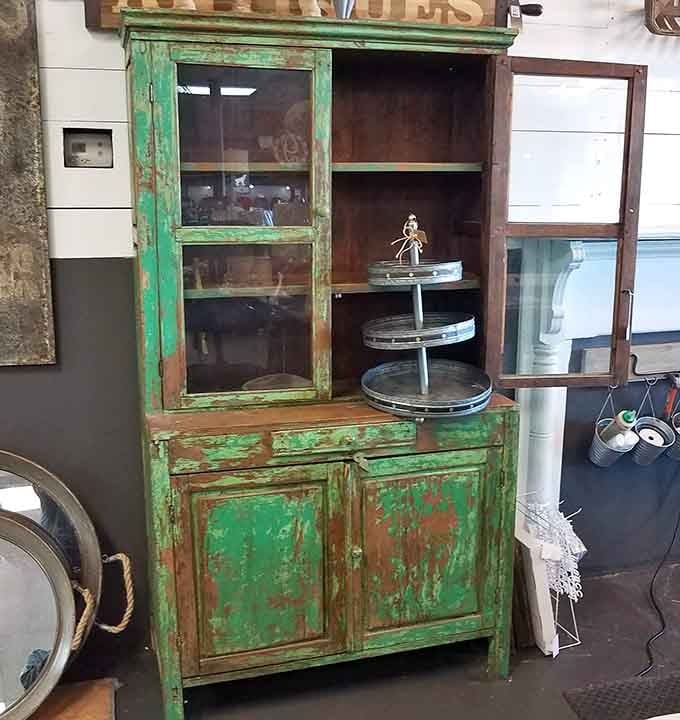 Weathered green cabinet exudes farmhouse charm, the kind of character you can't fake but can definitely afford here.