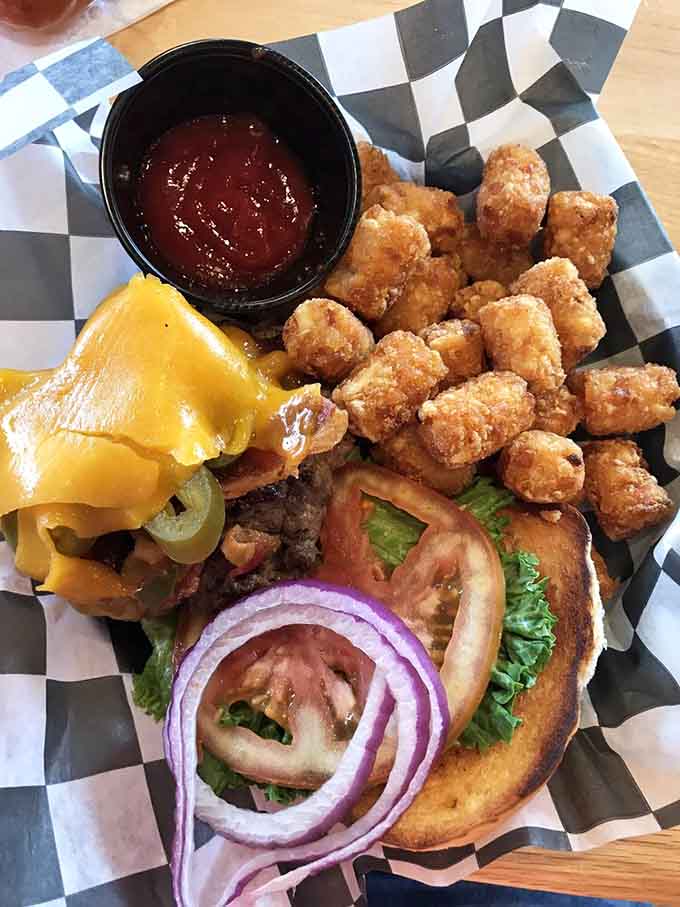 Beer can burger loaded with cheese, served alongside golden tater tots. This is what camping dreams are made of, friends.