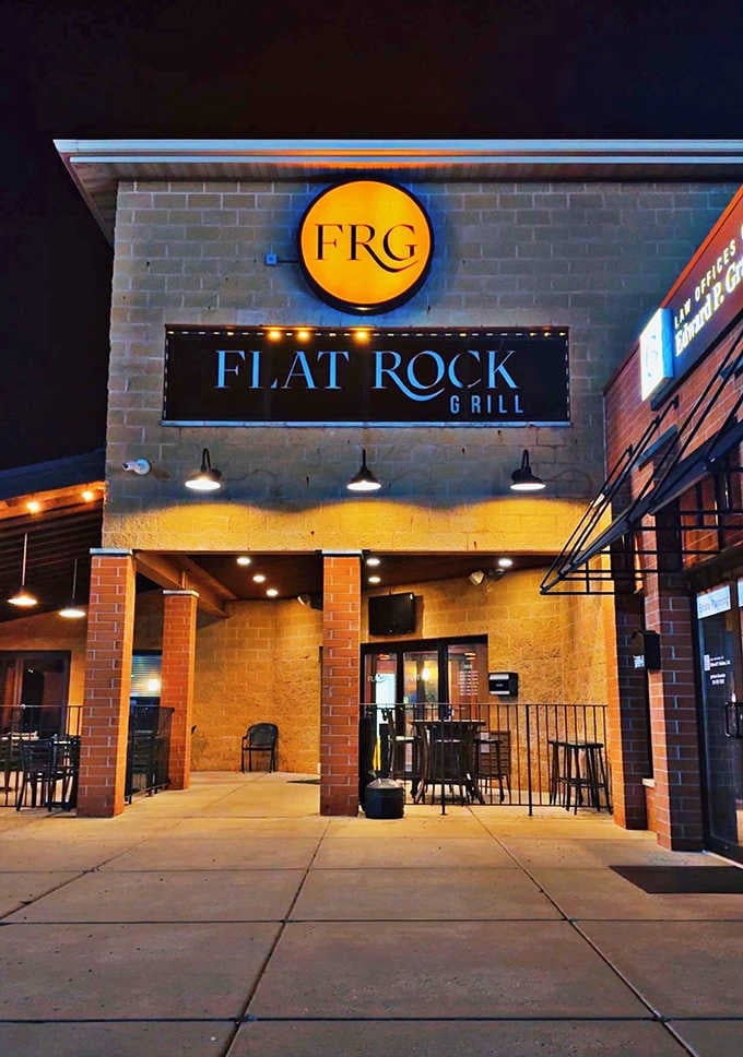 Flat Rock Grill's modern exterior lights up the evening, promising food that's worth staying past sunset.