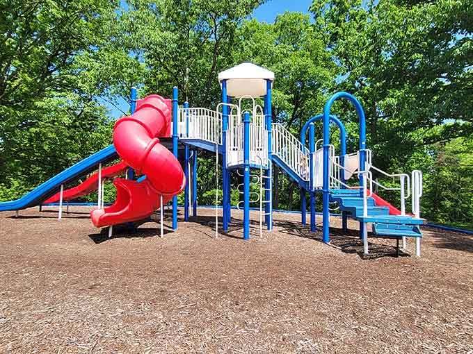 This playground's twisty red slide would make any grandkid squeal with delight while you rest on nearby benches.