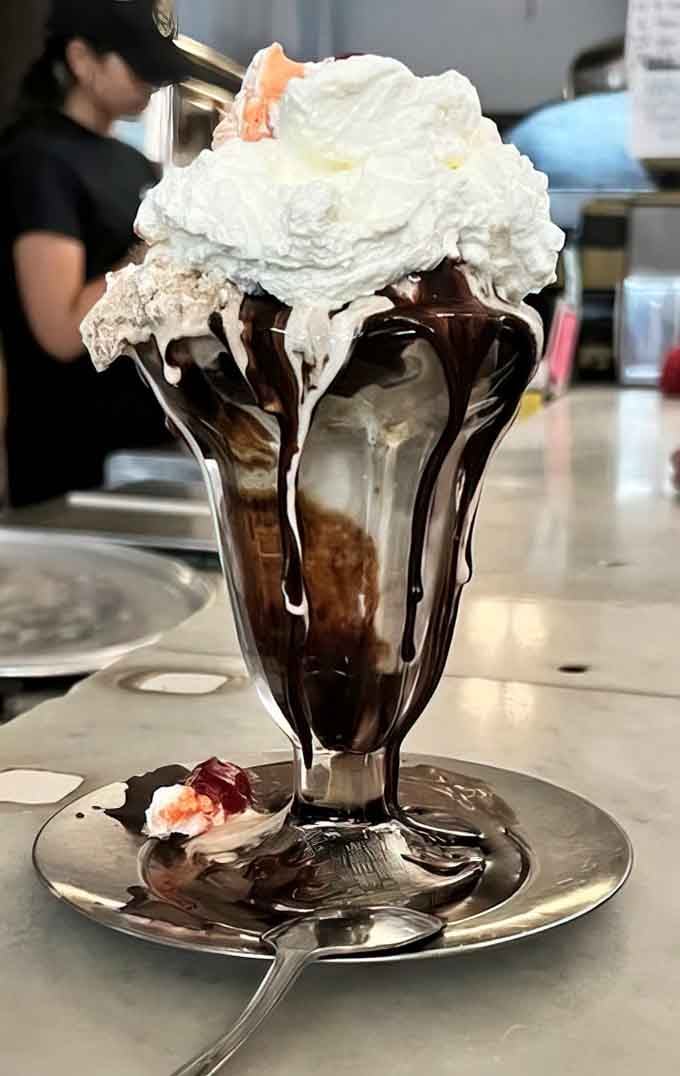 Hot fudge drips down like liquid velvet, creating abstract art you'll destroy happily with your spoon.