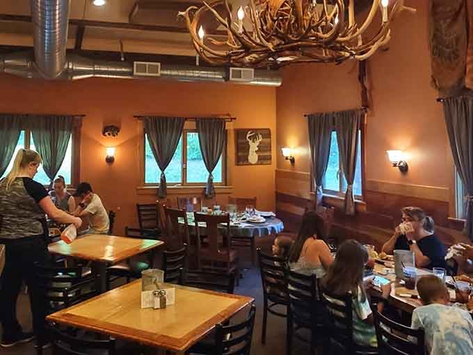 The antler chandelier overhead watches families gather, proving good food brings people together across generations and appetites.
