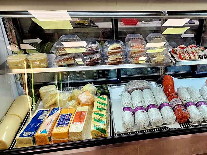 The deli case showcasing fresh meats, cheeses, and desserts that'll tempt you into ordering more than planned.