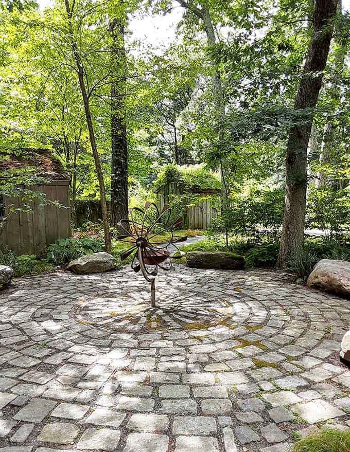 This circular stone patio feels like a secret meditation spot where you half expect to find woodland creatures holding meetings.