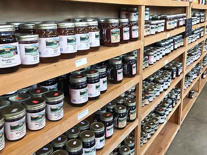 Shelves packed with homemade jams and jellies represent the farm's harvest preserved in delicious glass containers.