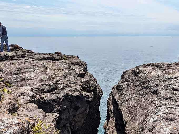 Standing at the edge of forever, where ancient rock meets endless water in dramatic fashion.