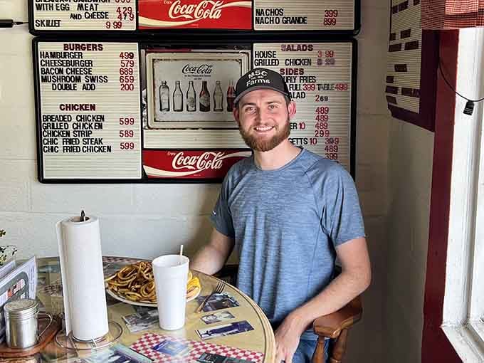 One happy customer with his curly fries proves that great food creates genuine smiles, not just Instagram moments.