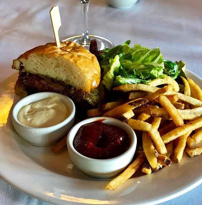 A juicy burger with golden fries and two dipping sauces is comfort food elevated to an art form.