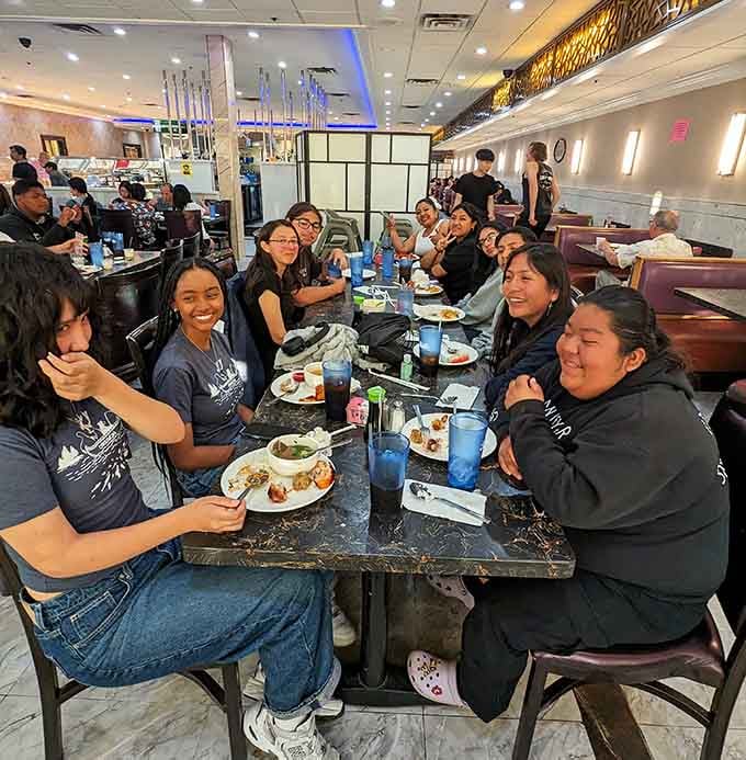 Happy diners gathered around tables, proving that unlimited food brings people together better than any social media platform ever could.